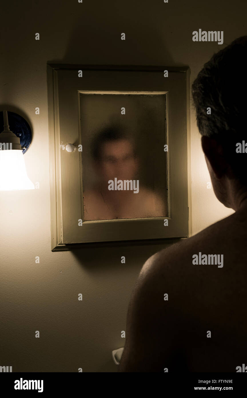 Man confronts his murky image in the mirror Stock Photo - Alamy