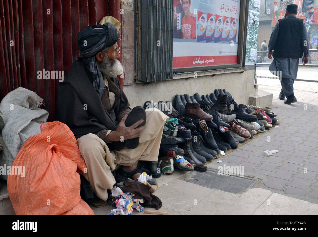 An aged man selling used shoes to earn his livelihood for support of ...
