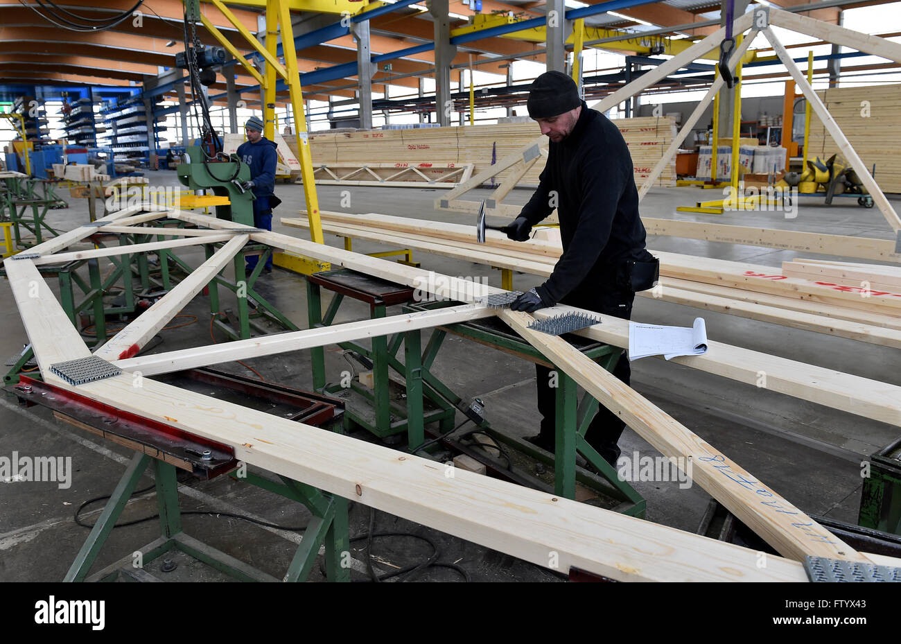 Neuruppin, Germany. 30th Mar, 2016. Carpenters work on a part of a roof ...