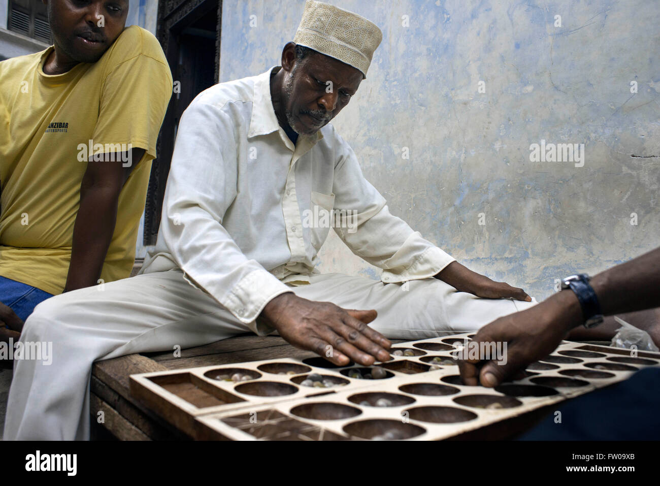 Bao players in Stone Town, Zanzibar. Bao is a traditional mancala board ...