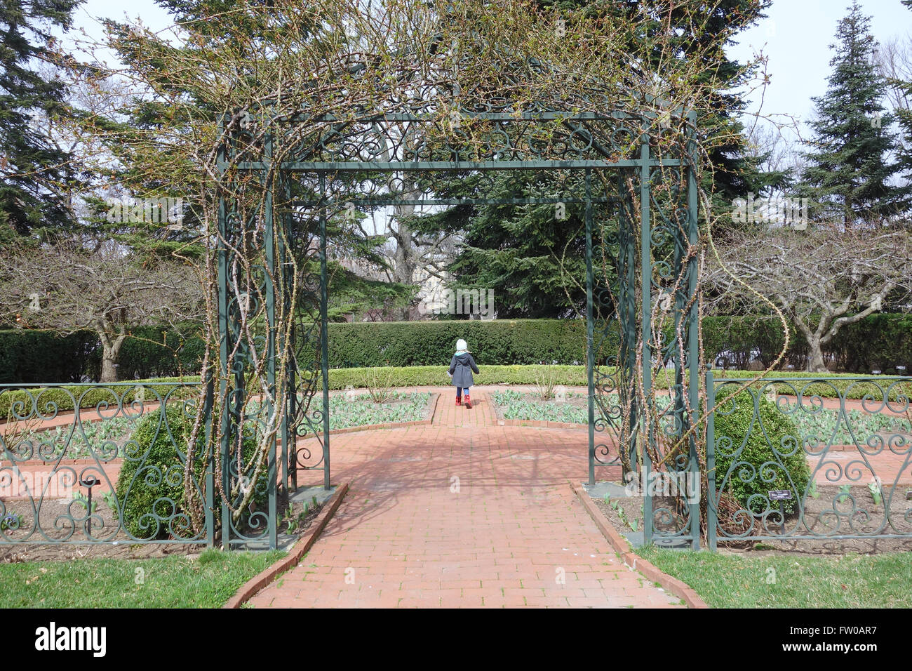girl walking through archway on garden path Stock Photo - Alamy