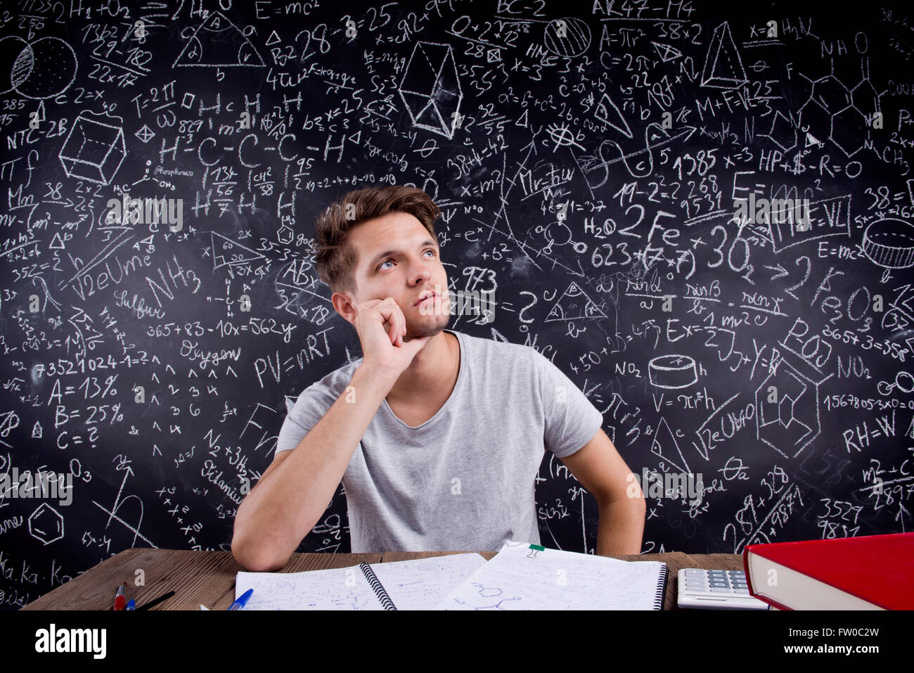 Hipster student doing his homework against a big blackboard Stock Photo ...