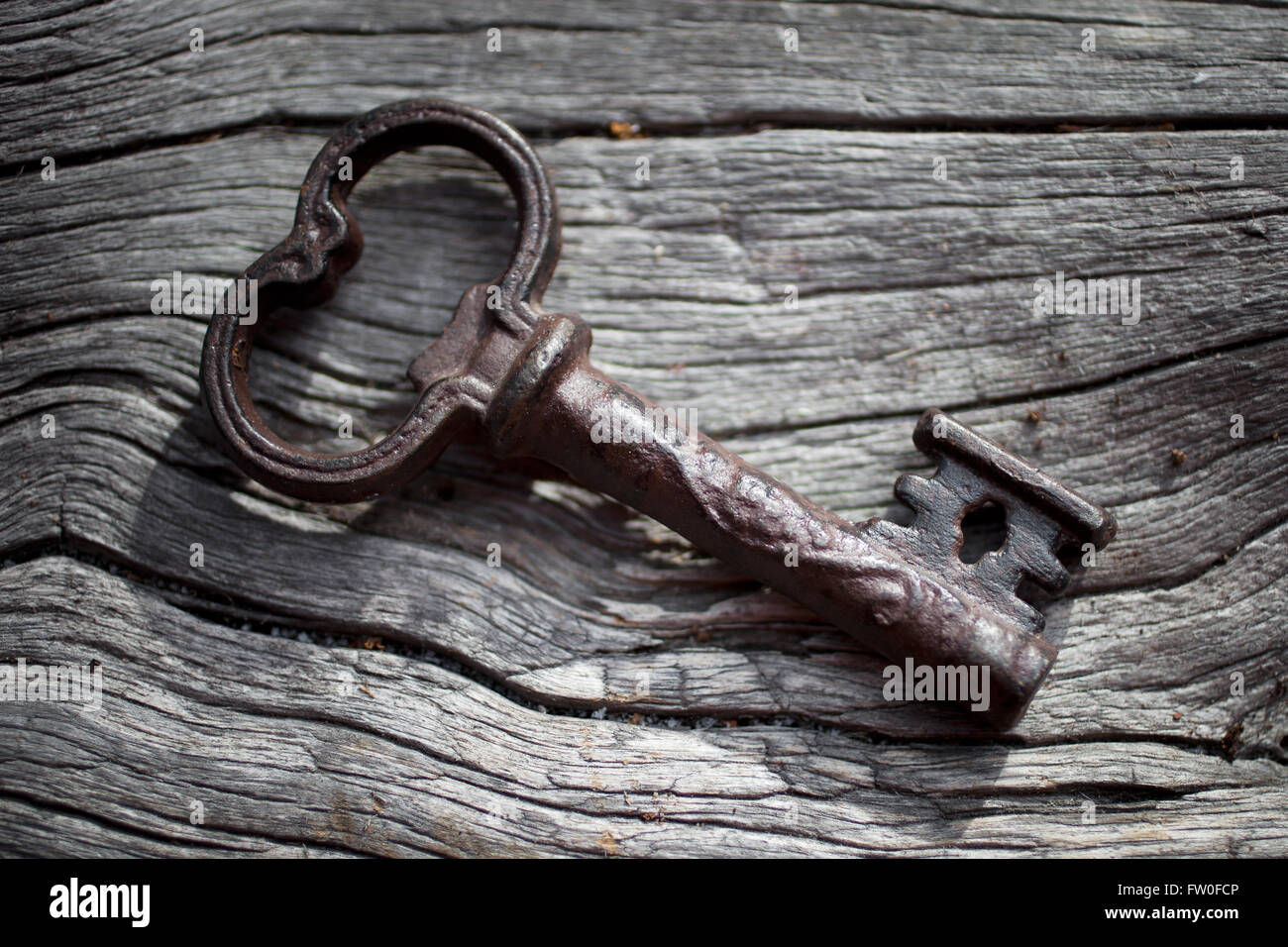 Old rustic key on wooden background Stock Photo - Alamy
