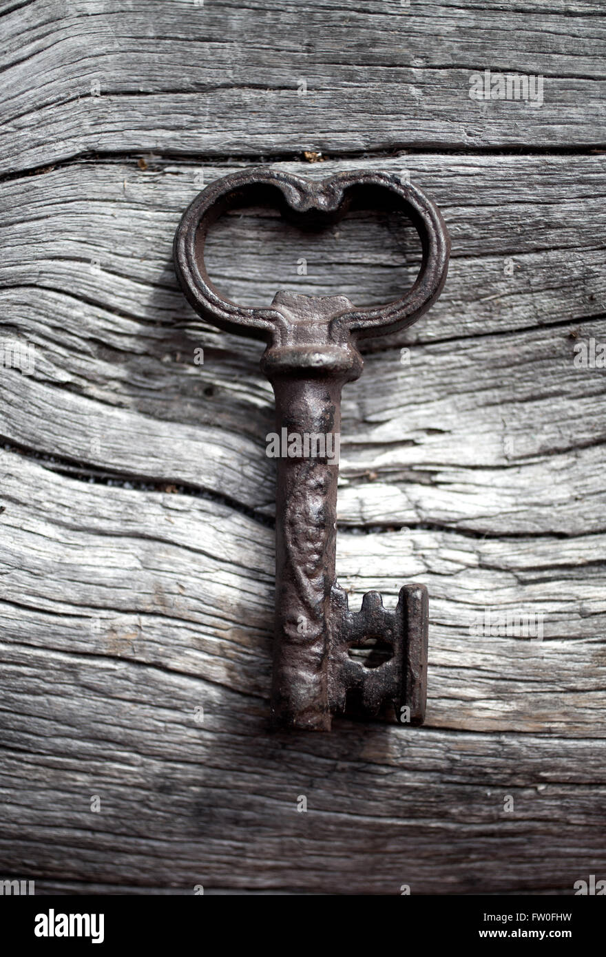 Old rustic key on wooden background Stock Photo - Alamy
