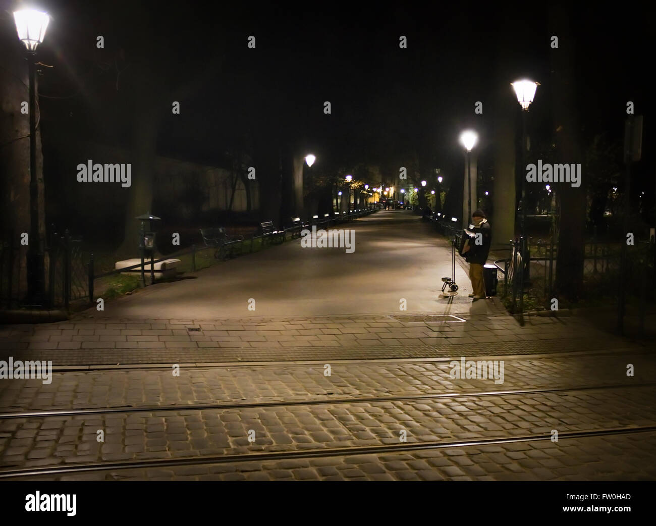 Street musician playing accordion on a dark, windy and stormy night in ...
