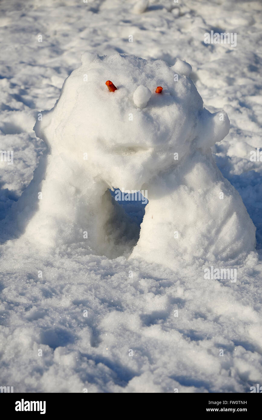 Snowman creature standing in winter landscape, made by children. A ...