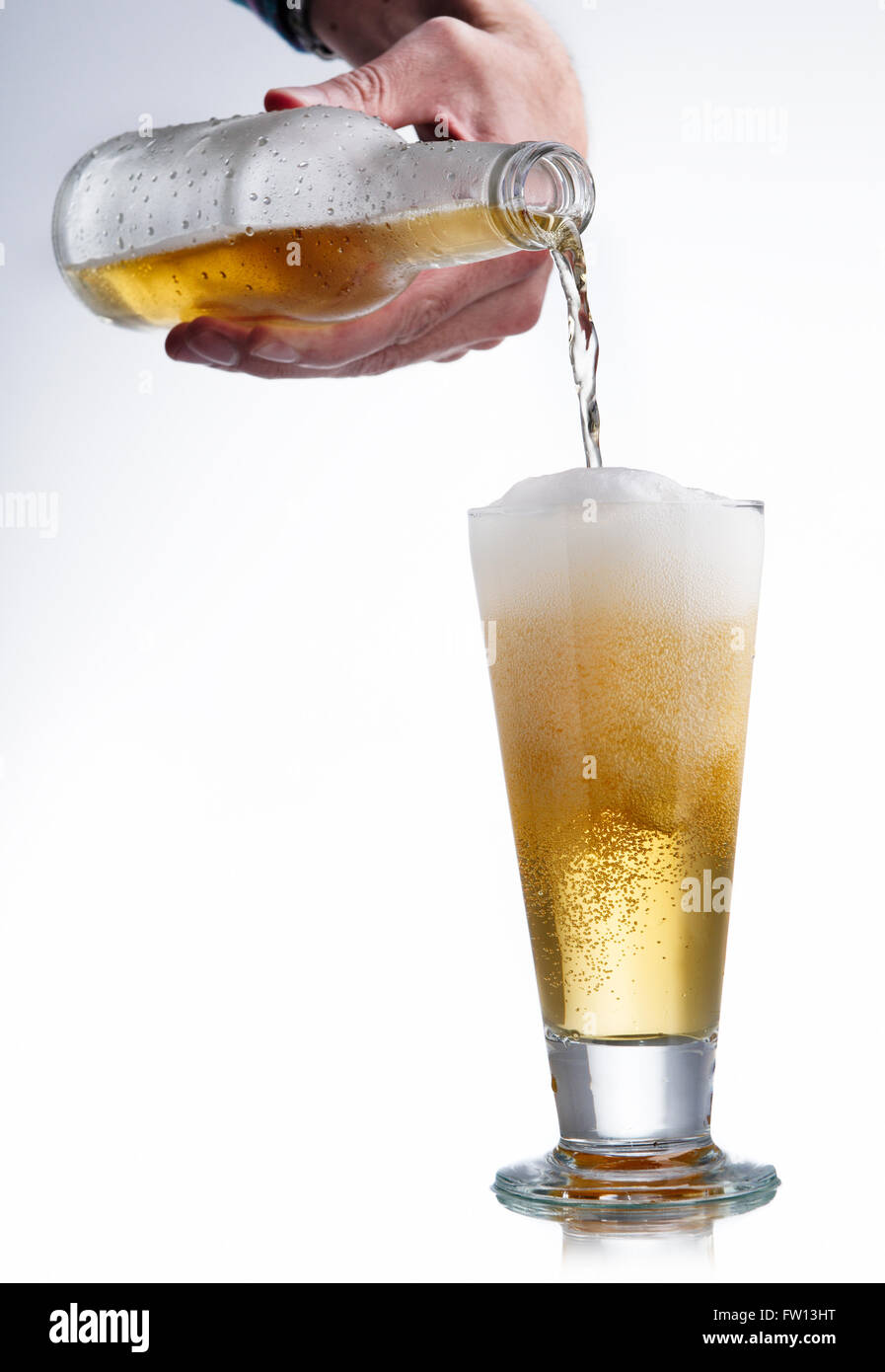 Non-glossy white beer bottle, back lighted showing a glowing golden ...