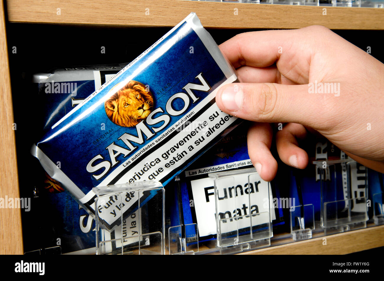 Hand removing a packet of Samson Hand Rolling Tobacco on sale in a ...