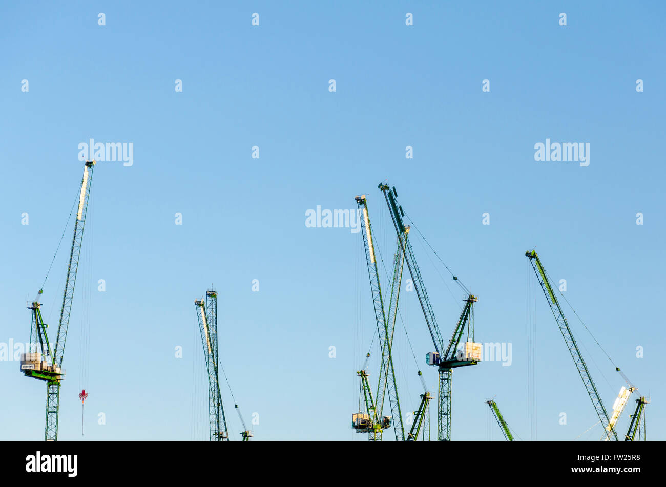 A view of the top of cranes in London. crane, cranes, sky, blue, UK ...