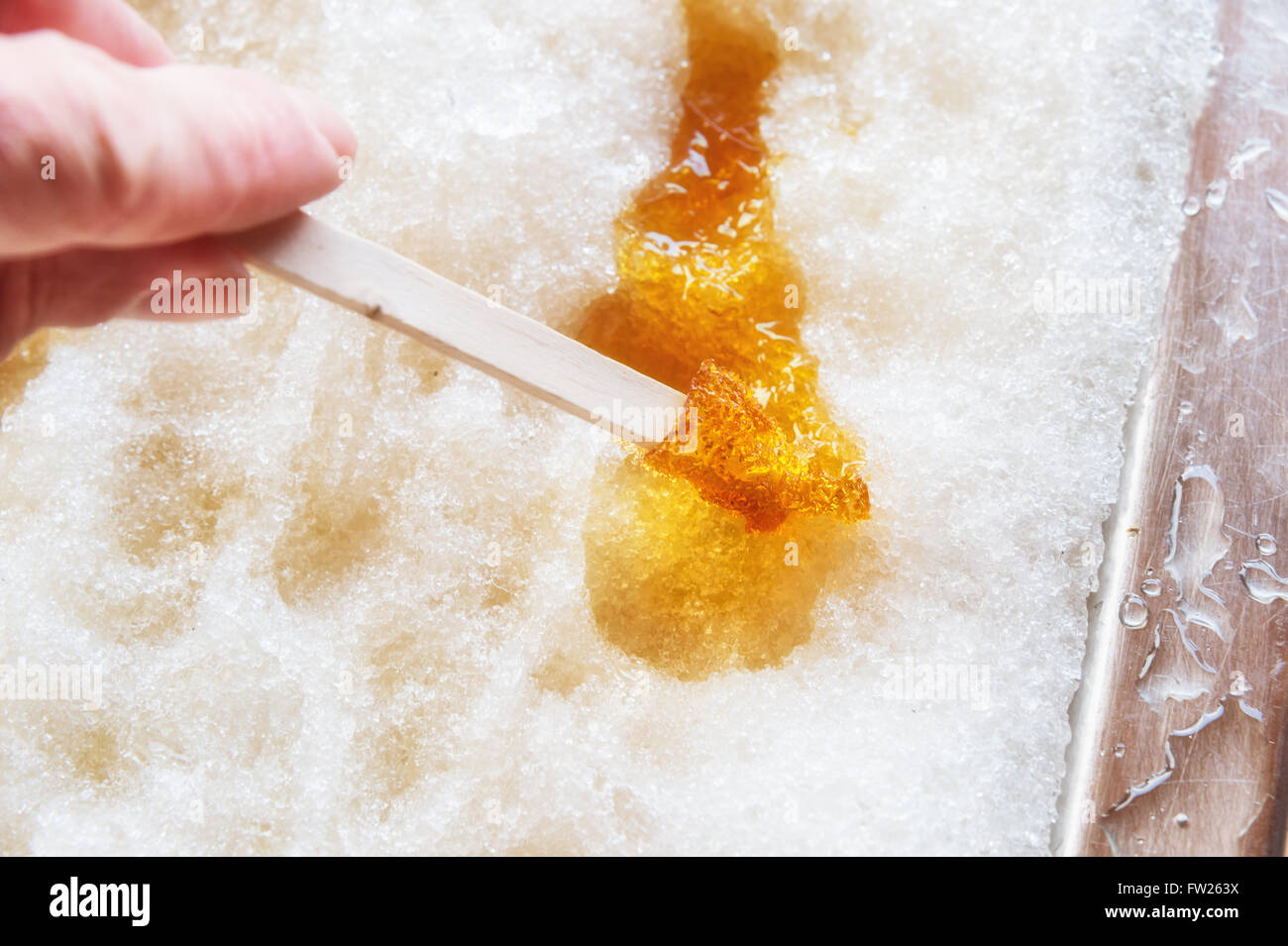 Zoomed photo of a maple taffy rolled over snow during sugar shack ...