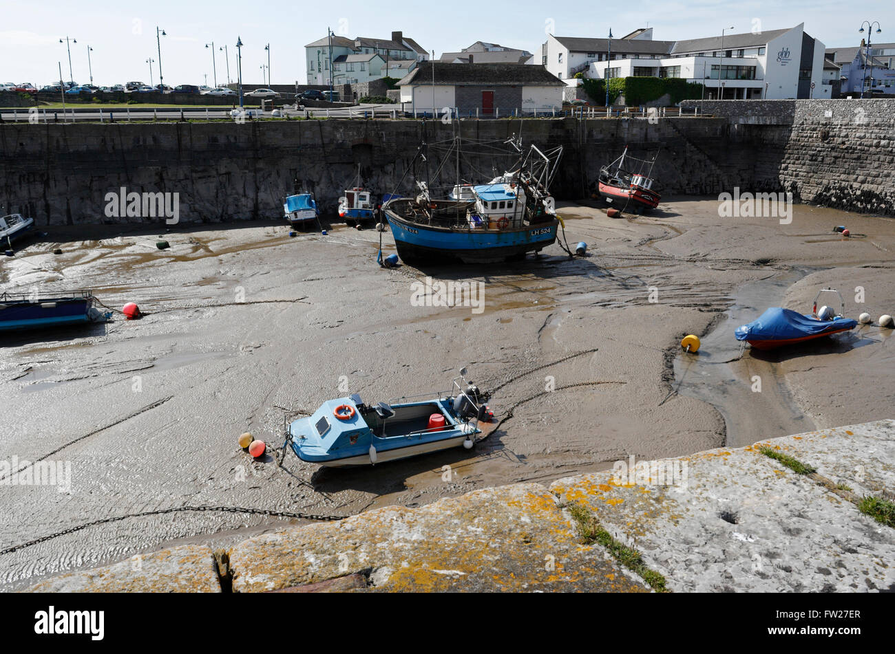 Fishing boats on the mud low tide at Porthcawl harbour, Wales UK. Welsh ...