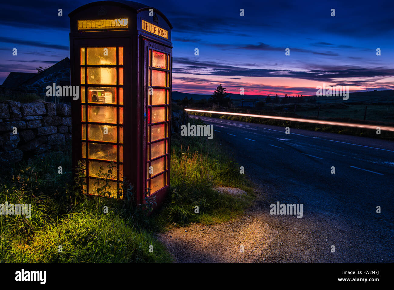 Red phone booth illuminated at night Stock Photo - Alamy