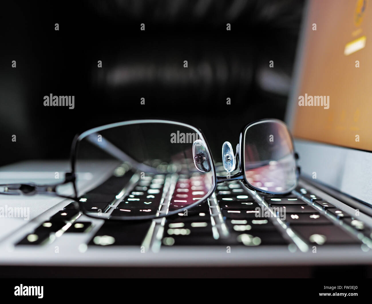 Reading eyeglasses on an elegance laptop keyboard, shallow depth of ...