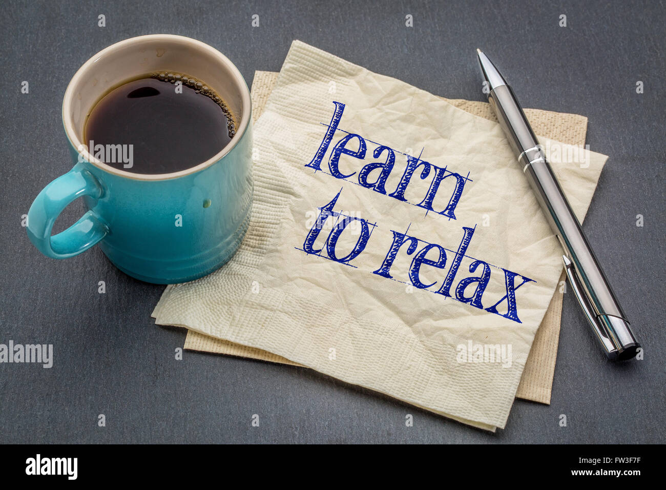 learn to relax advice or reminder - handwriting on a napkin with cup of ...