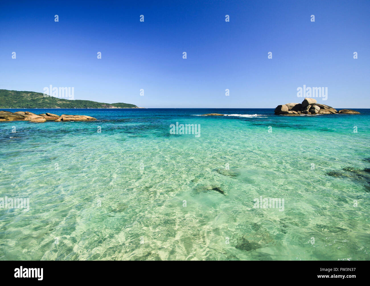 pure blue water of ocean beach with rocks on background and mountain ...