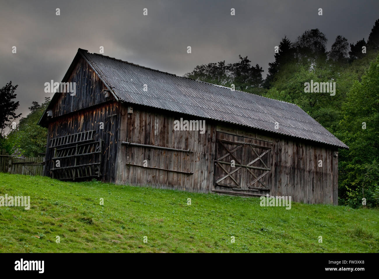 old wood vintage barn on a hill with grass in village museum before ...