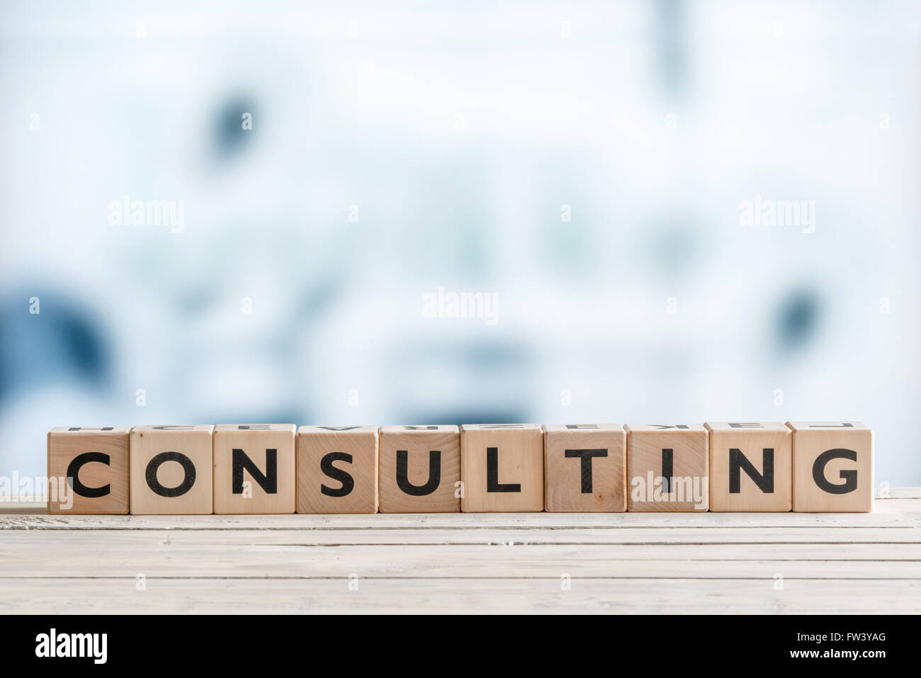 Consulting sign on an office desk on blue background Stock Photo - Alamy