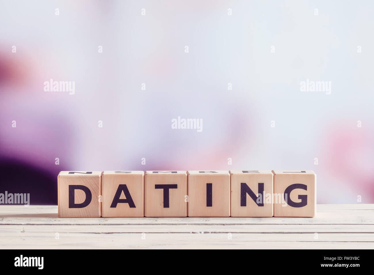 Dating sign in wood on a table on violet background Stock Photo - Alamy