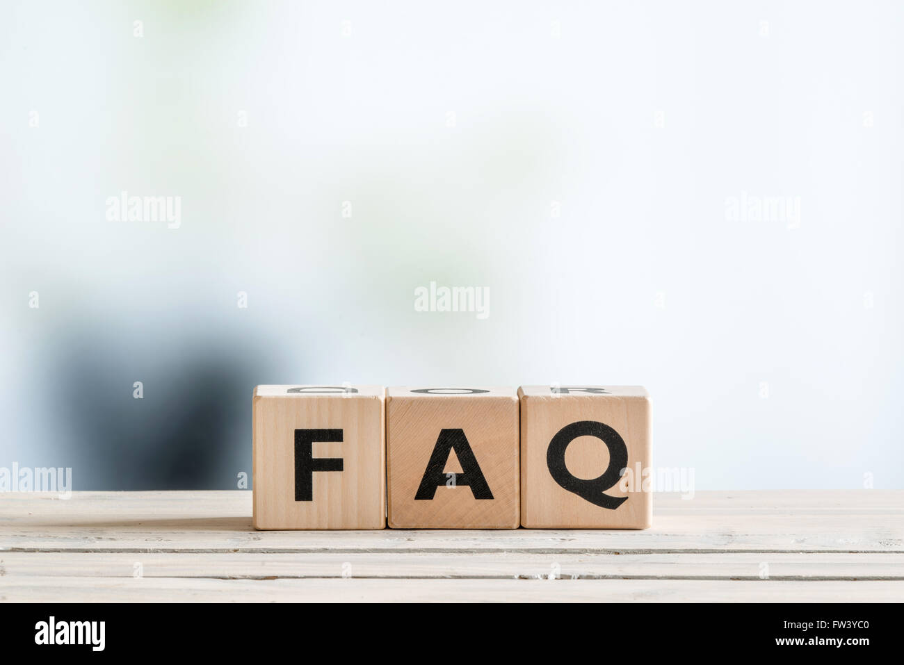 FAQ sign made of wood on an office table Stock Photo - Alamy