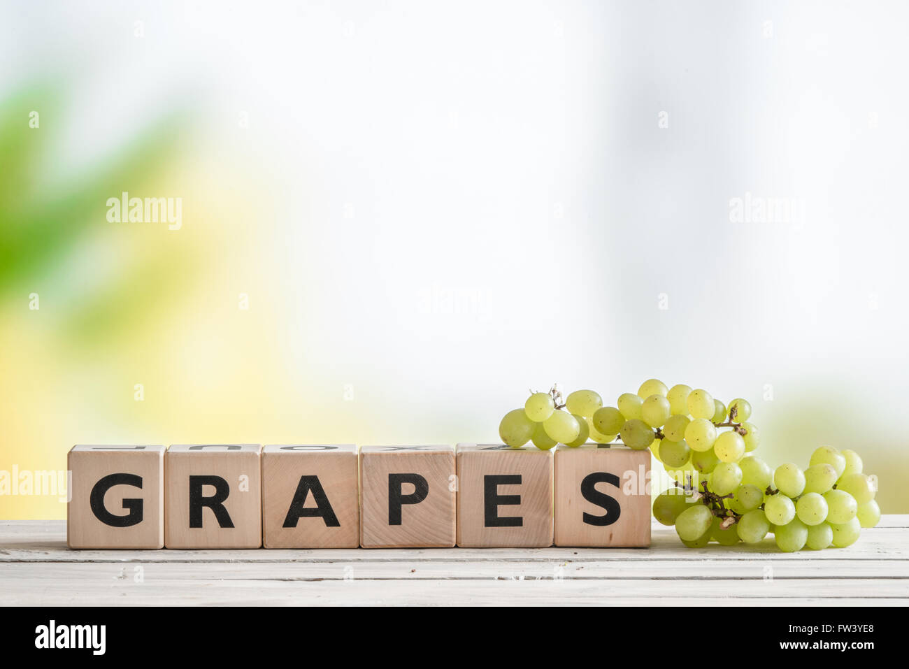 Grapes sign with green grapes on a table Stock Photo - Alamy