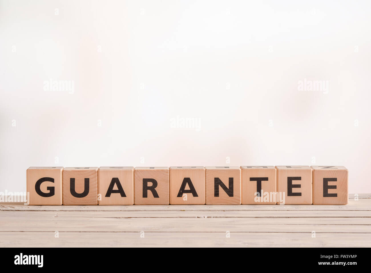 Guarantee sign made of blocks on a wooden desk Stock Photo - Alamy