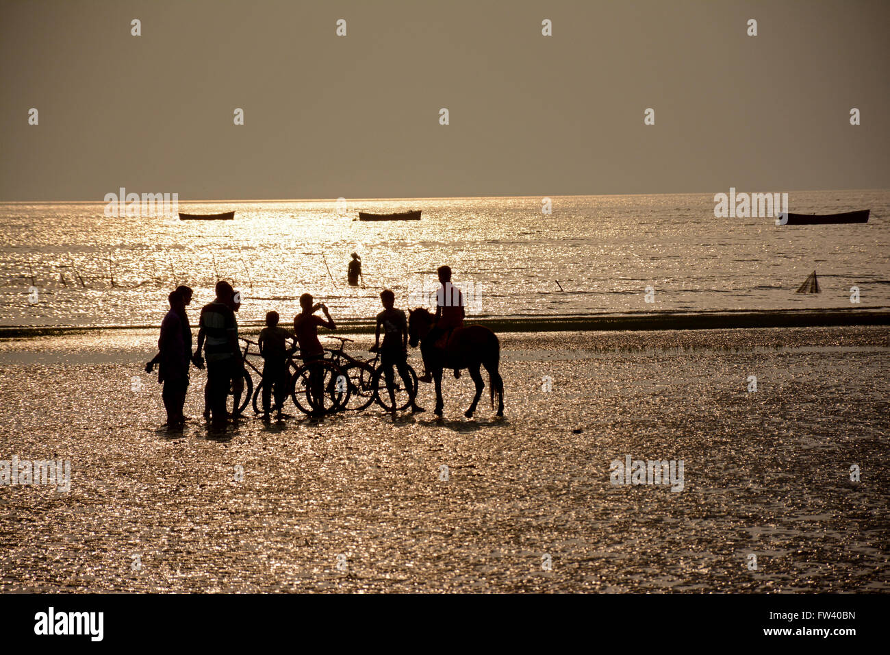 Gather of few boys at beach during sunset Stock Photo - Alamy