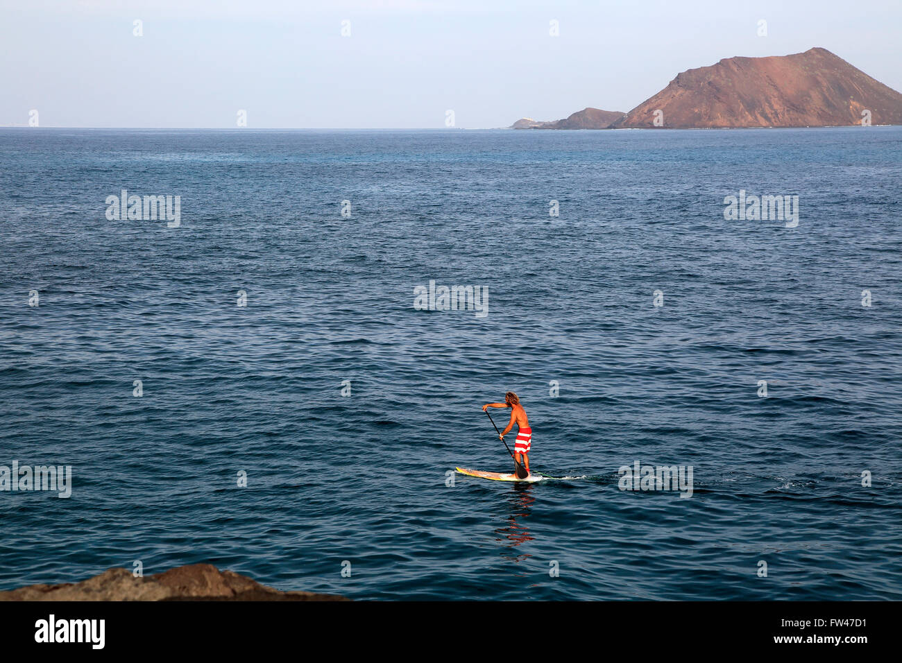Man paddle boarding in sea at Corralejo, Fuerteventura, Canary Islands ...