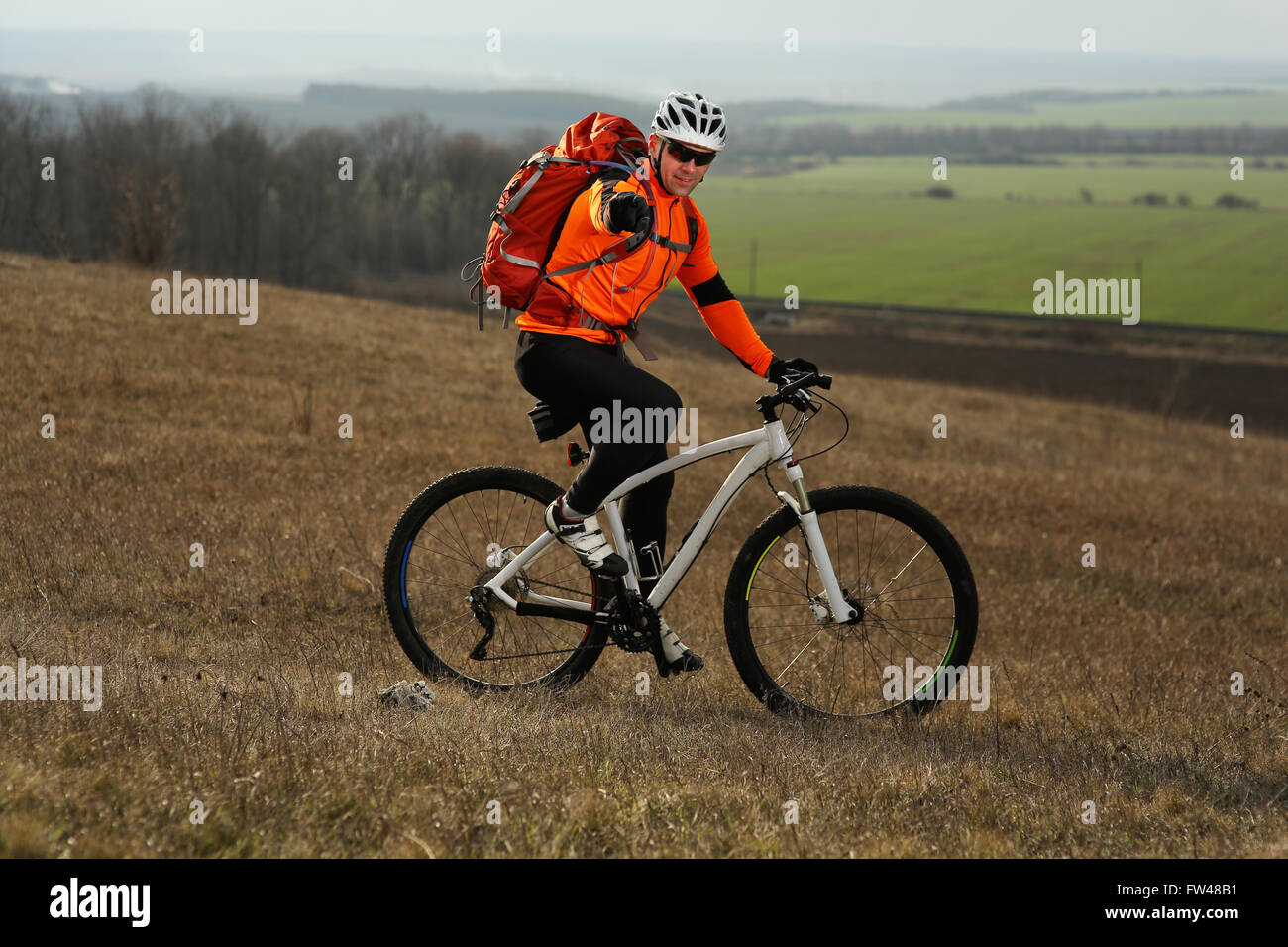 Man cyclist with backpack riding the bicycle Stock Photo - Alamy