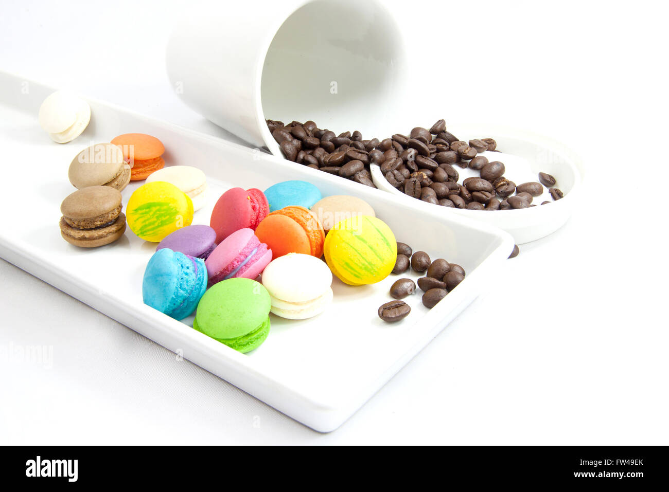 Coffee bean and mini macaroon colorful in white caramic plate on white ...