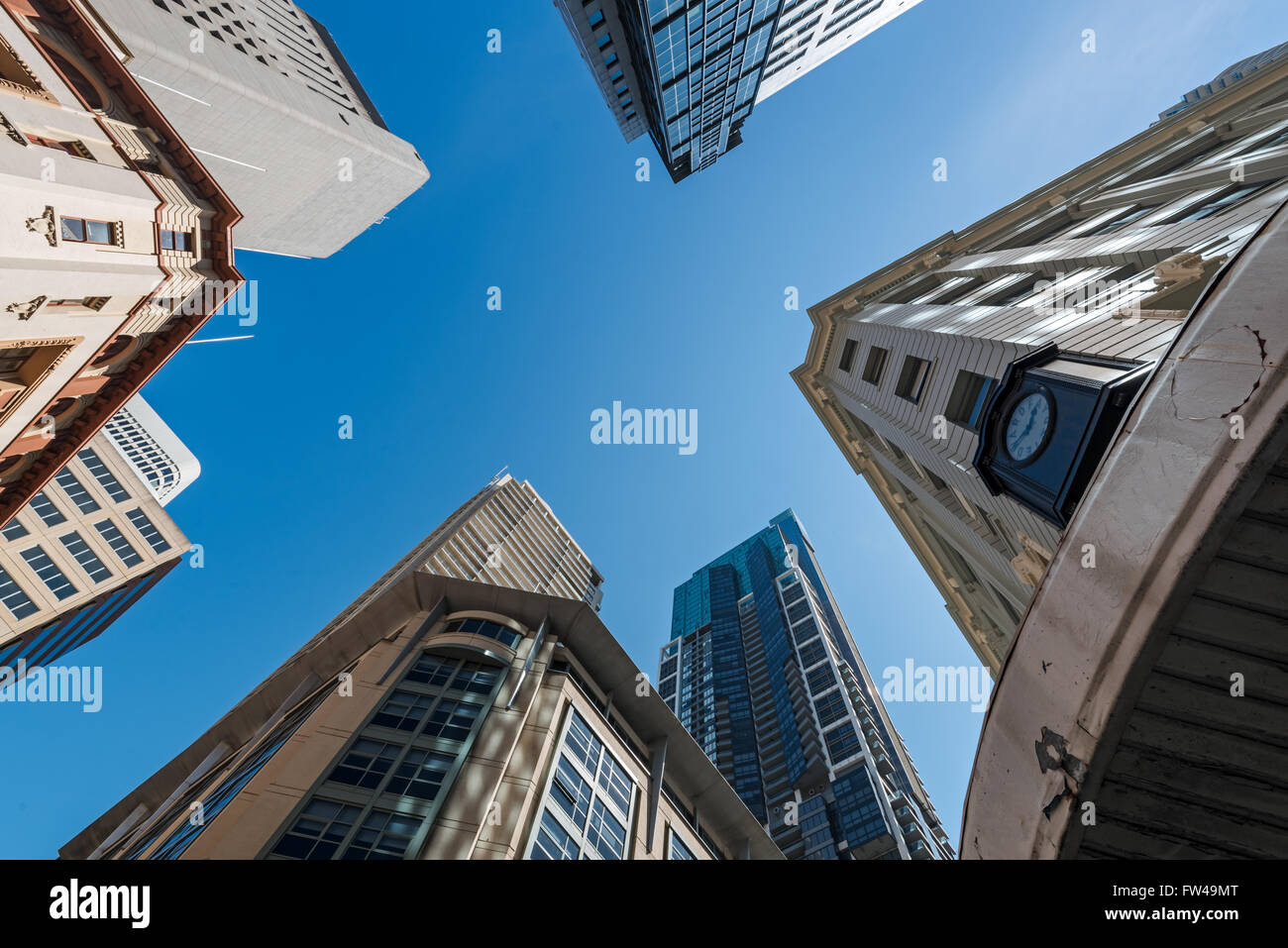 Five tall buildings viewed from bottom looking up with blue sky during ...