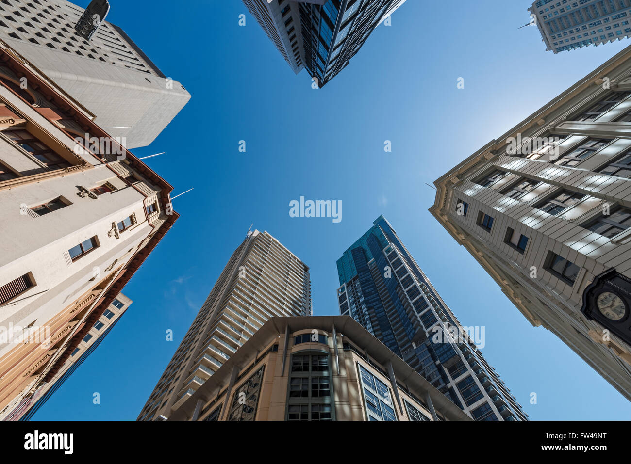 Five tall buildings viewed from bottom looking up with blue sky during ...