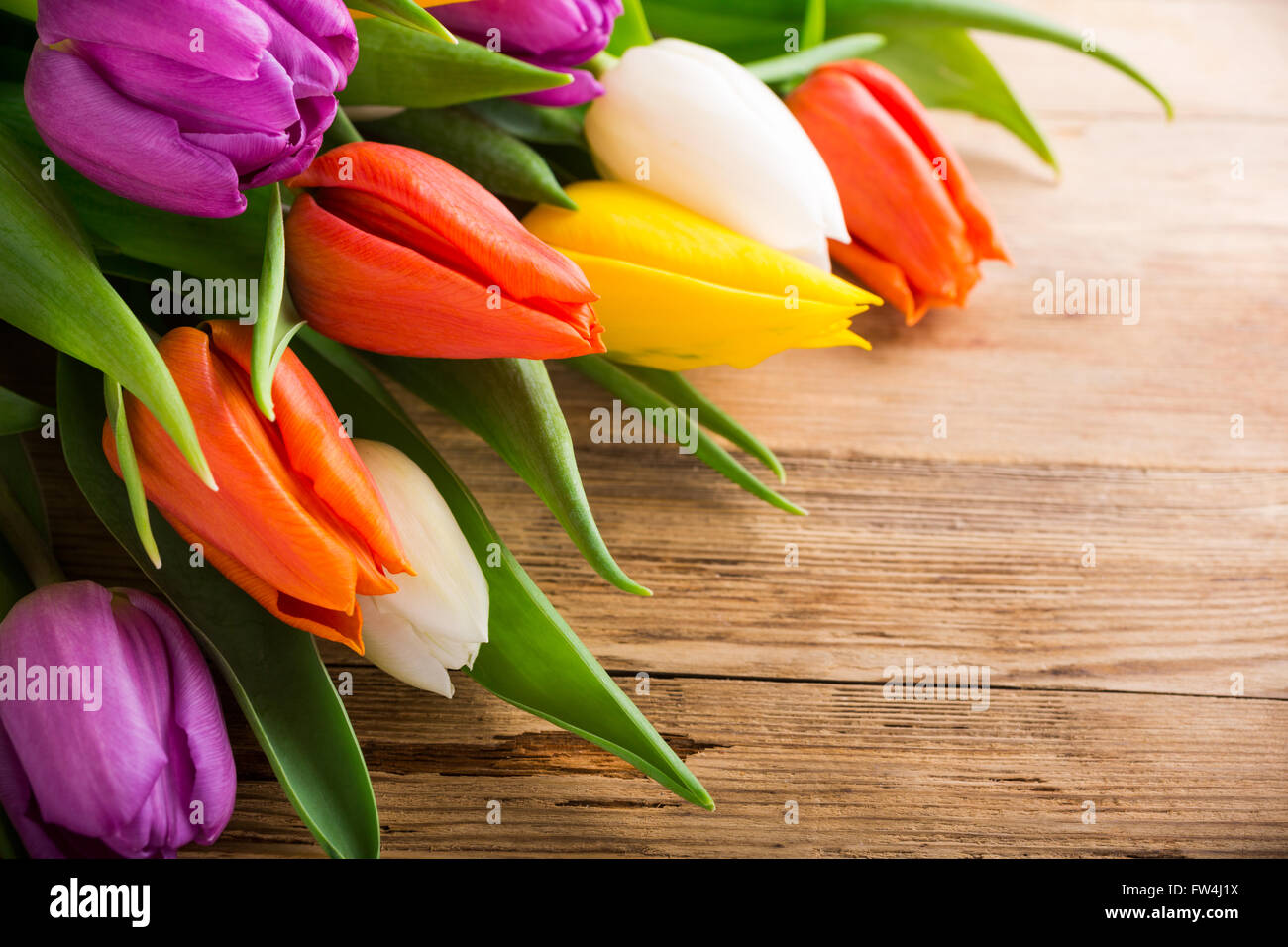 Colorful tulips on old wooden background Stock Photo - Alamy