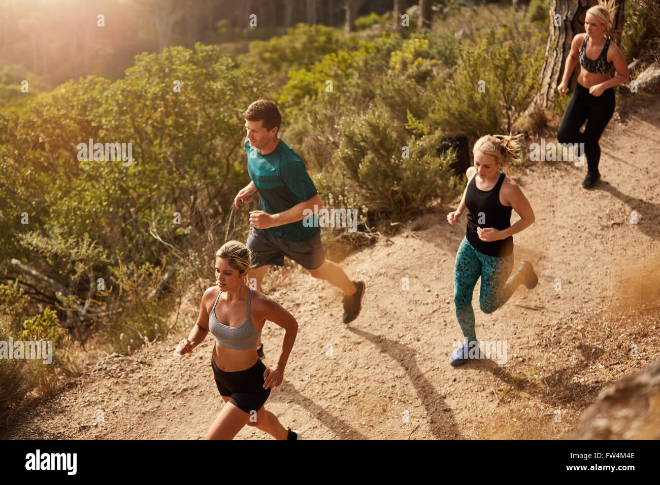 Active young people running on mountain trail. Top view of running club ...