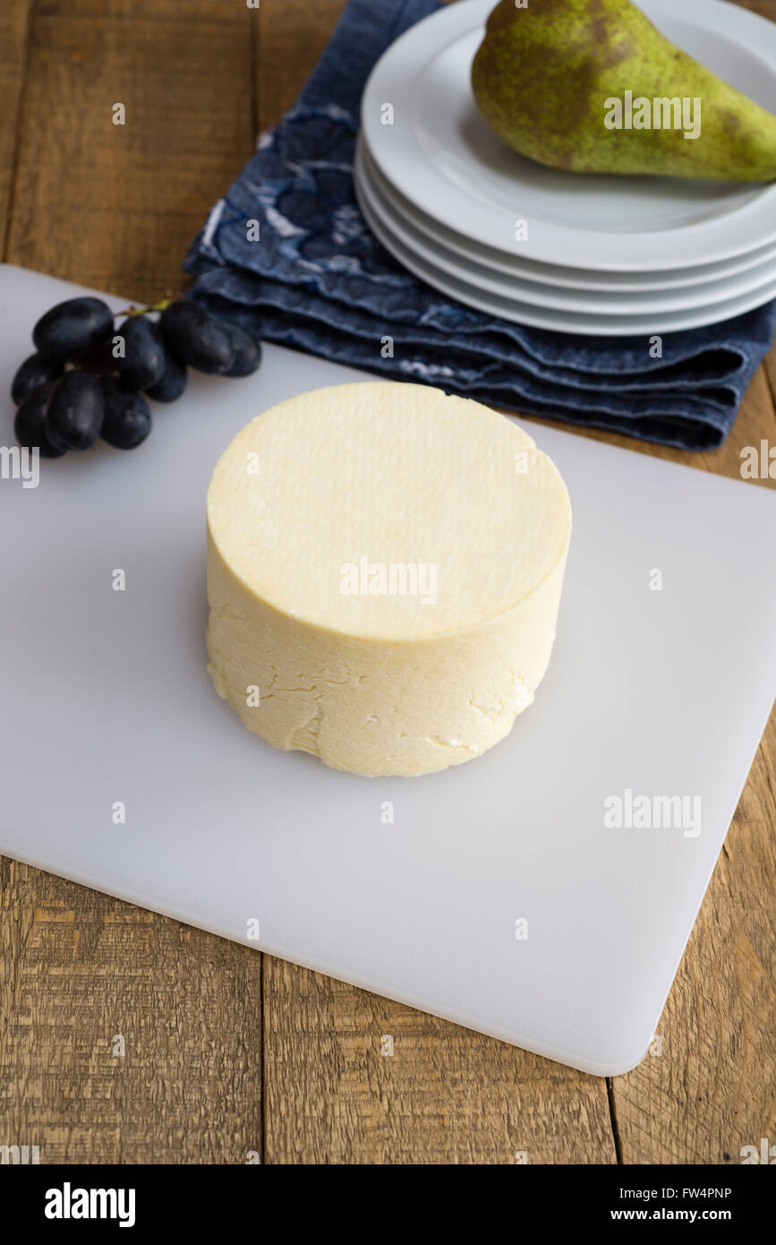 Truckle of homemade Cheshire cheese on an old wooden kitchen table ...