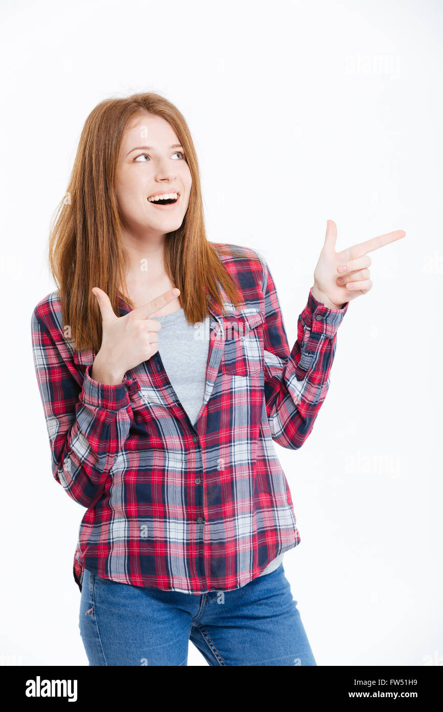 Smiling woman pointing finger away isolated on a white background Stock ...