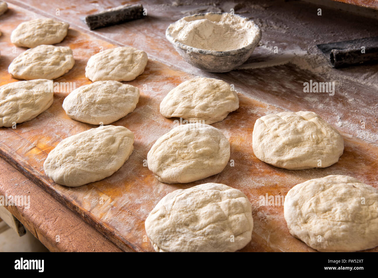 Making fresh bread in a bakery with individual round portions of dough ...