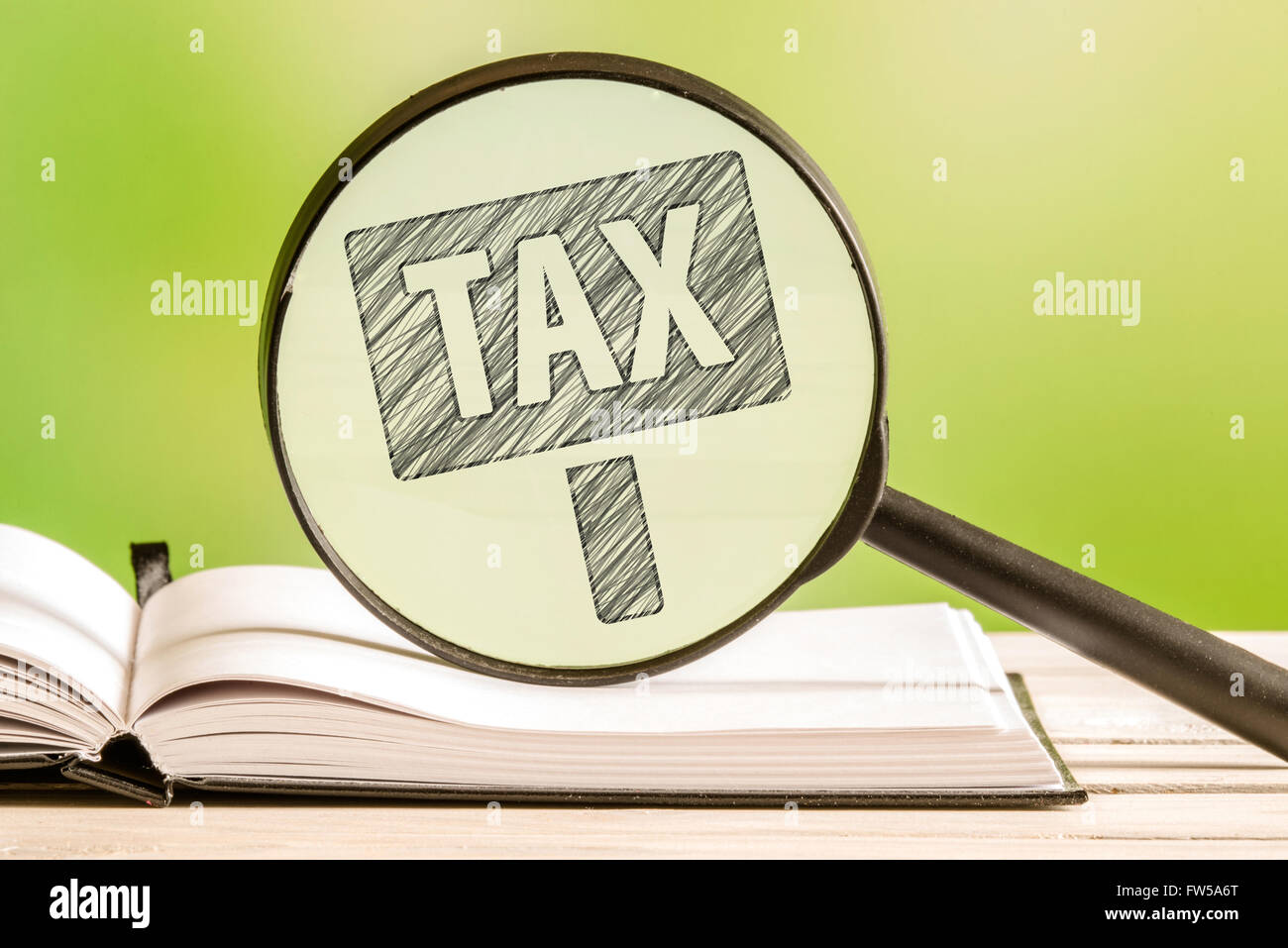 Tax information with a pencil drawing of a taxes sign in a magnifying ...