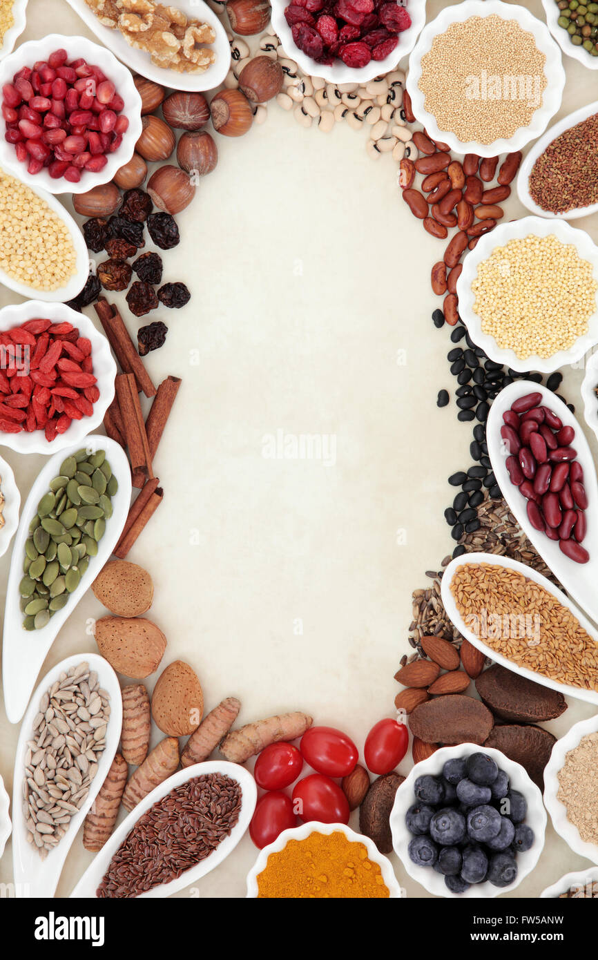 Super food border in porcelain dishes over parchment paper background ...