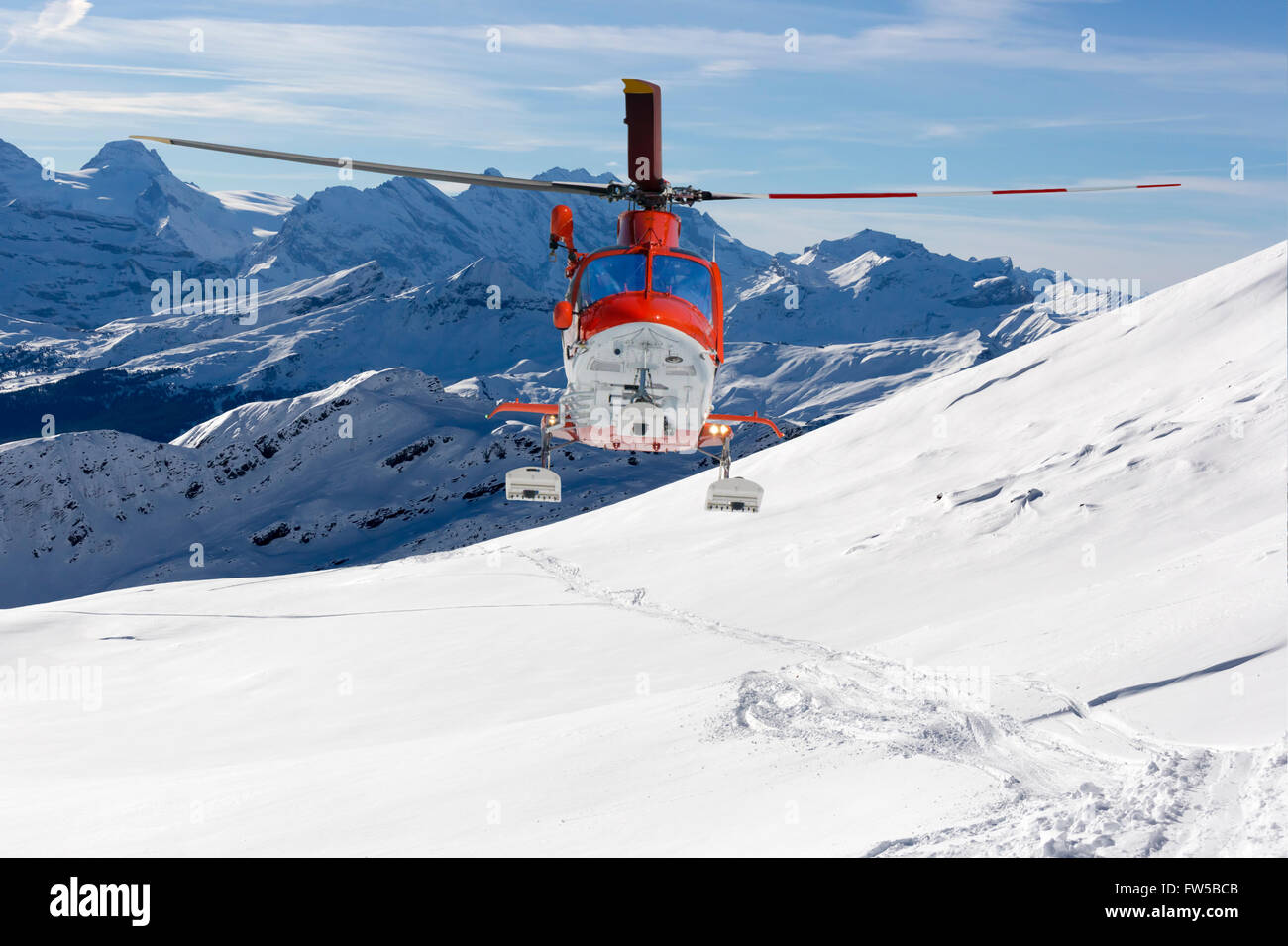 Rescue helicopter lands in snow capped mountains Stock Photo - Alamy
