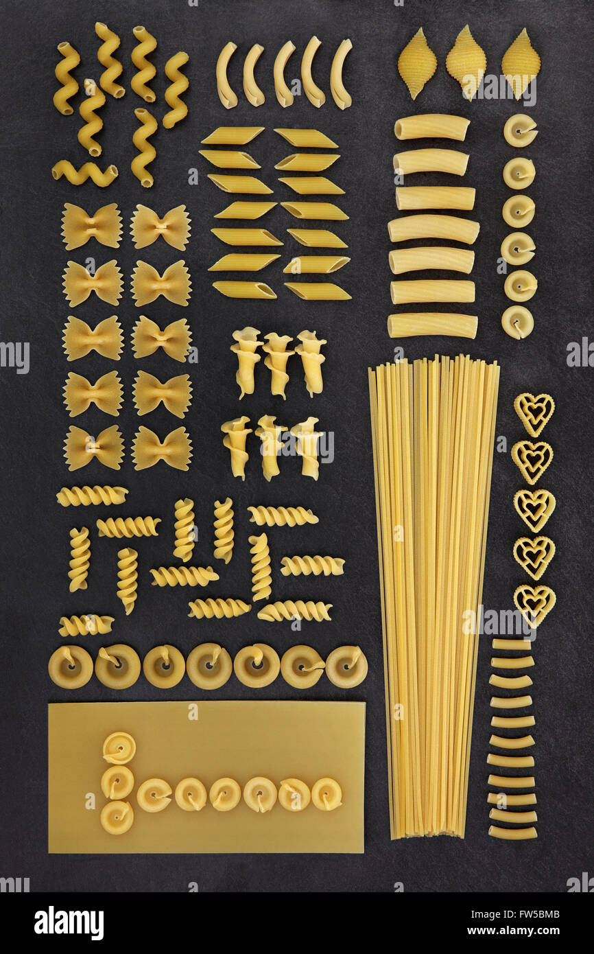 Large dried pasta food selection forming an abstract background on gray ...