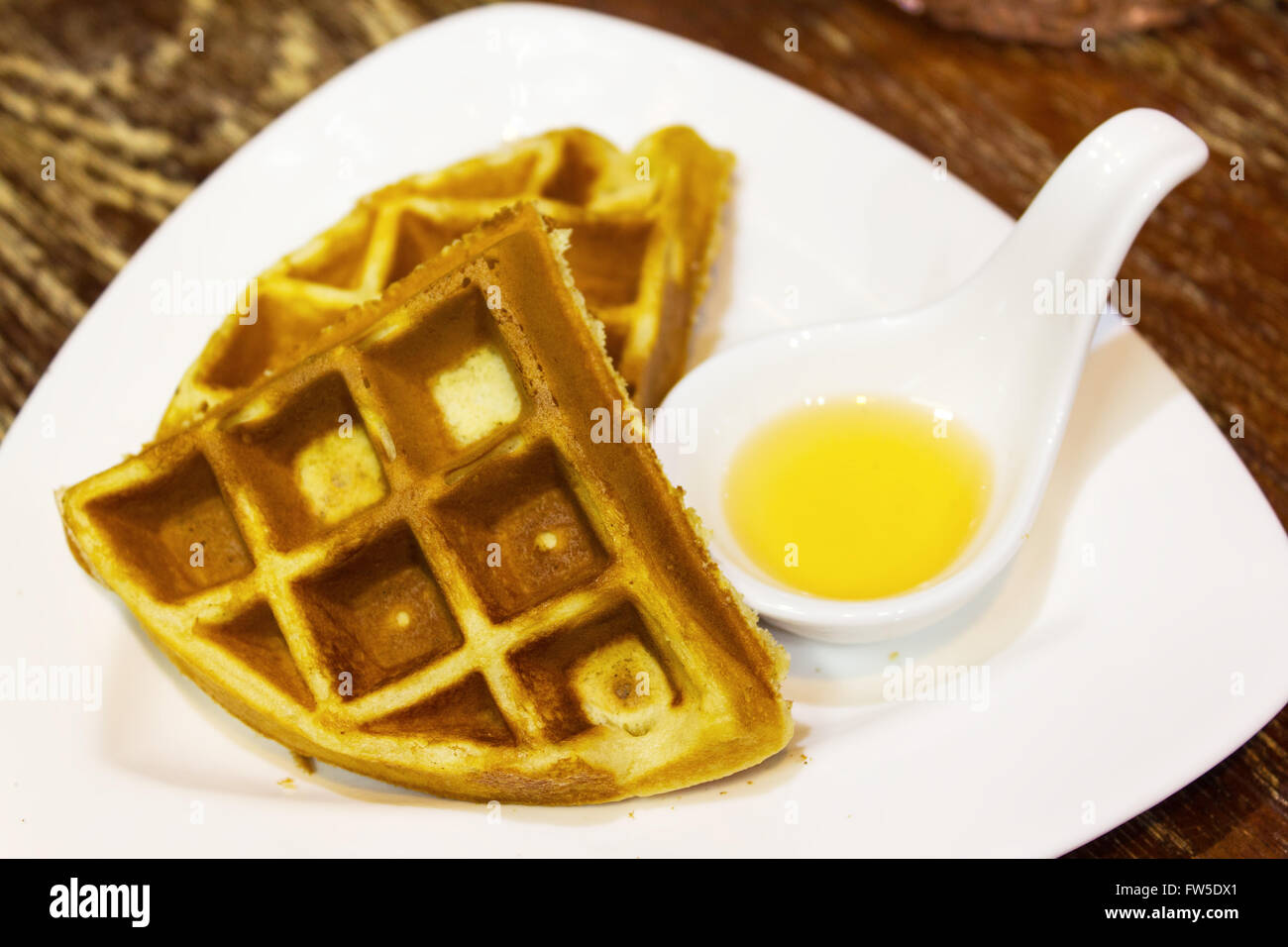 Waffles with honey in white plate on old wood table Stock Photo - Alamy