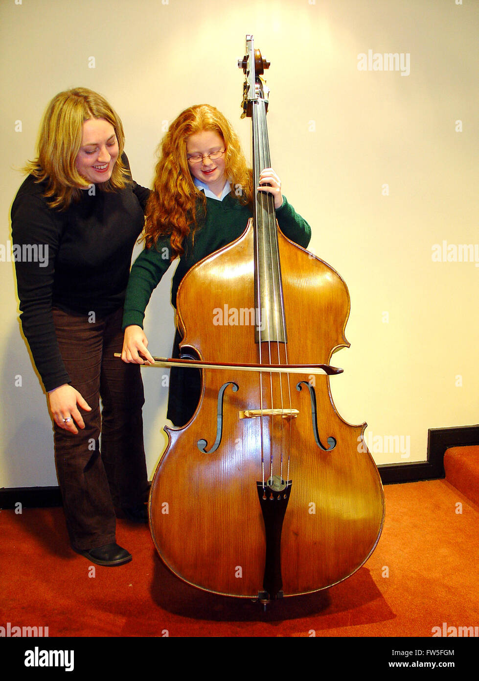 Young Irish girl and her teacher instructing her on how to play the ...