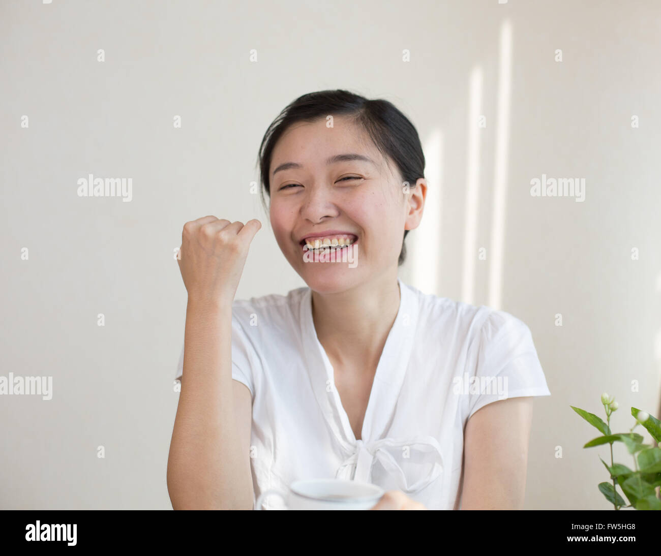 An Asian woman in a white shirt is laughing Stock Photo - Alamy