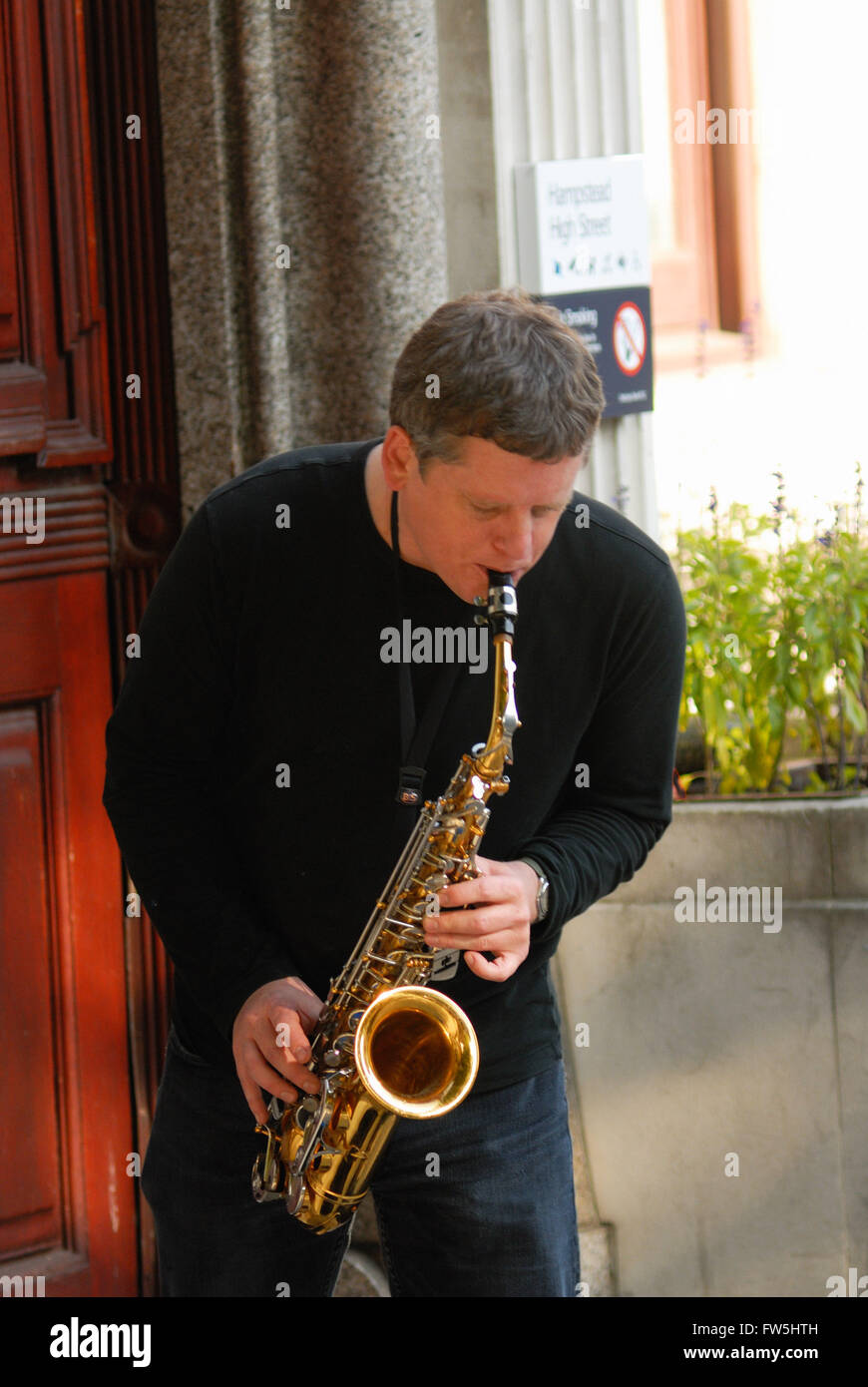 Busker playing alto saxophone hi-res stock photography and images - Alamy