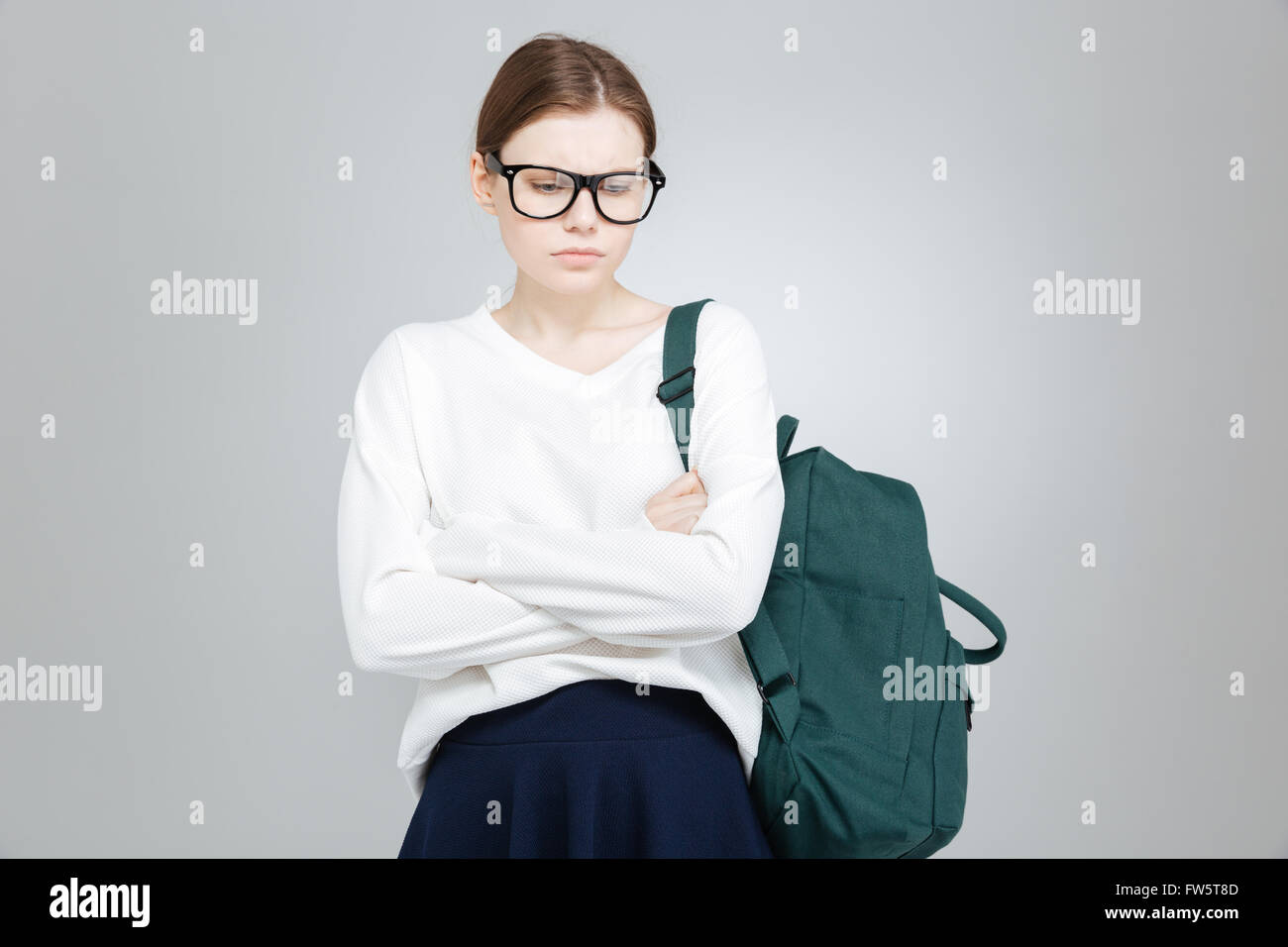 Sad depressed girl student in glasses with backpack standing with hands ...