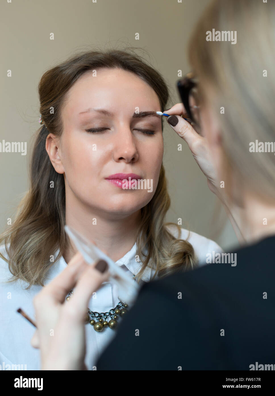 Make-up artist cleaning skin on model's face Stock Photo - Alamy