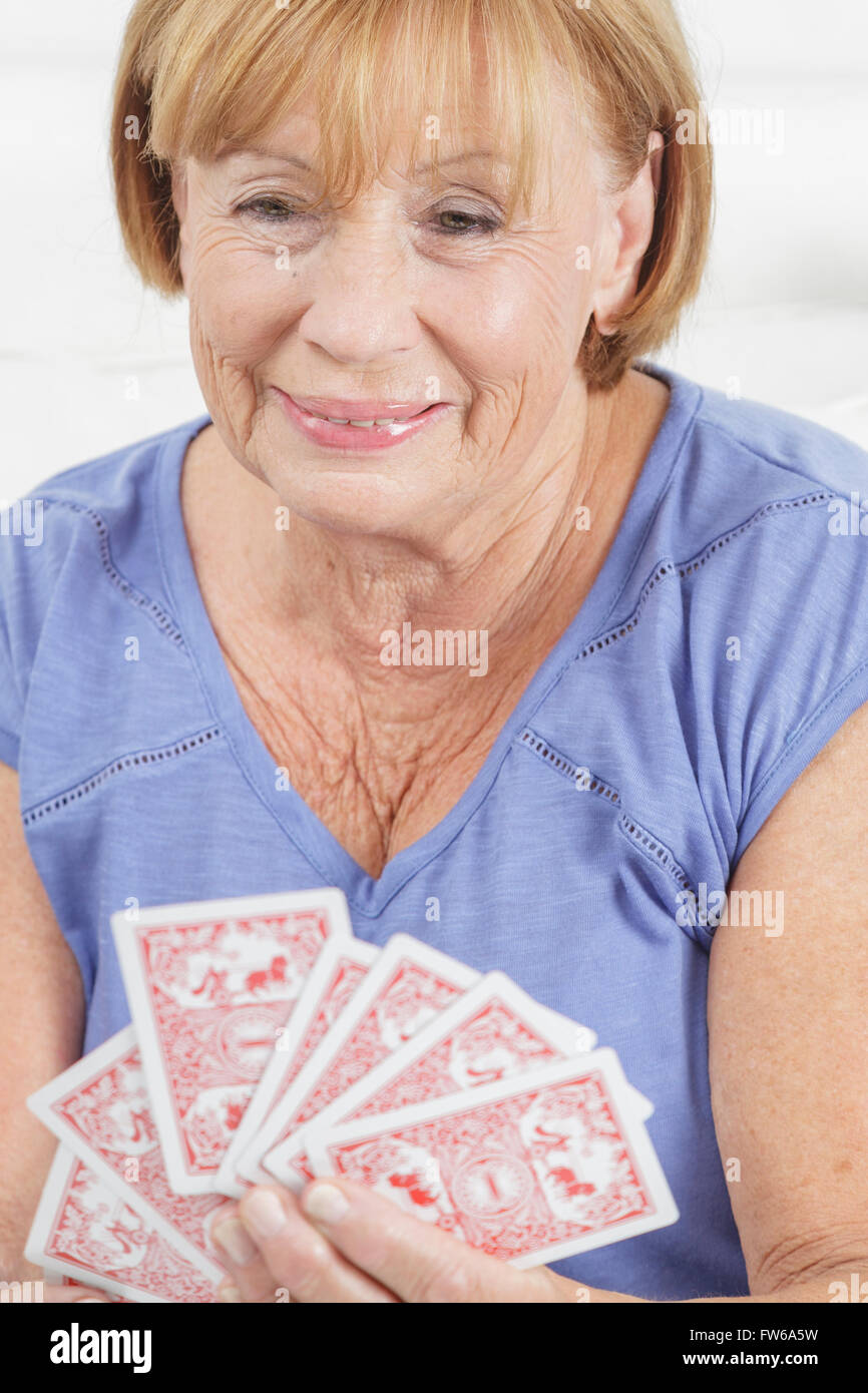 senior woman on couch playing cards with husband Stock Photo - Alamy
