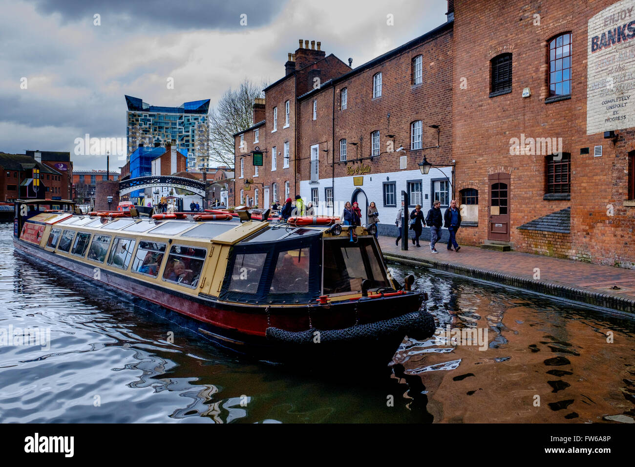 A canal boat on Birmingham Canal Old Line in the centre of the city of ...