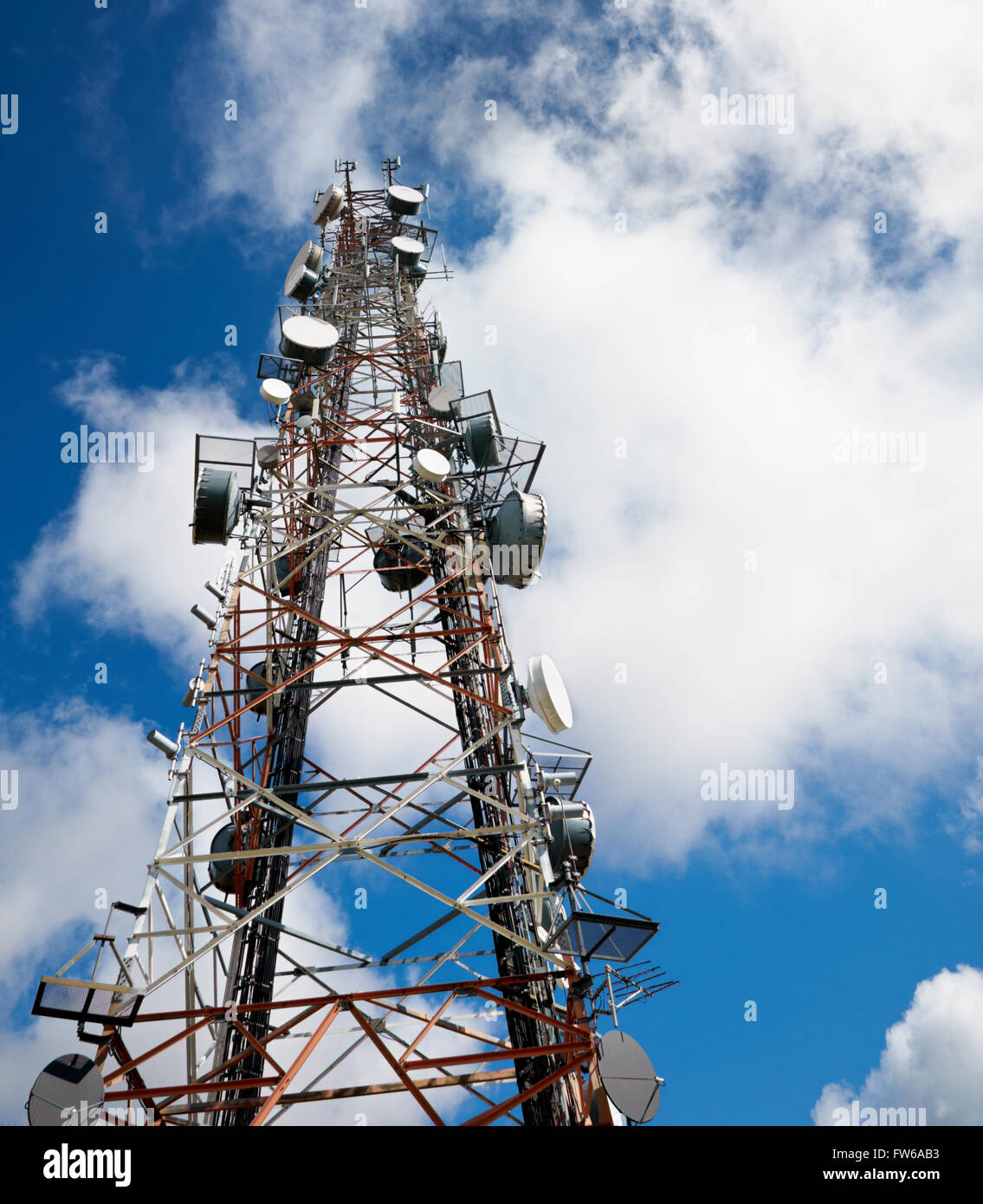 High Voltage Communications tower against a blue cloudy sky Stock Photo ...
