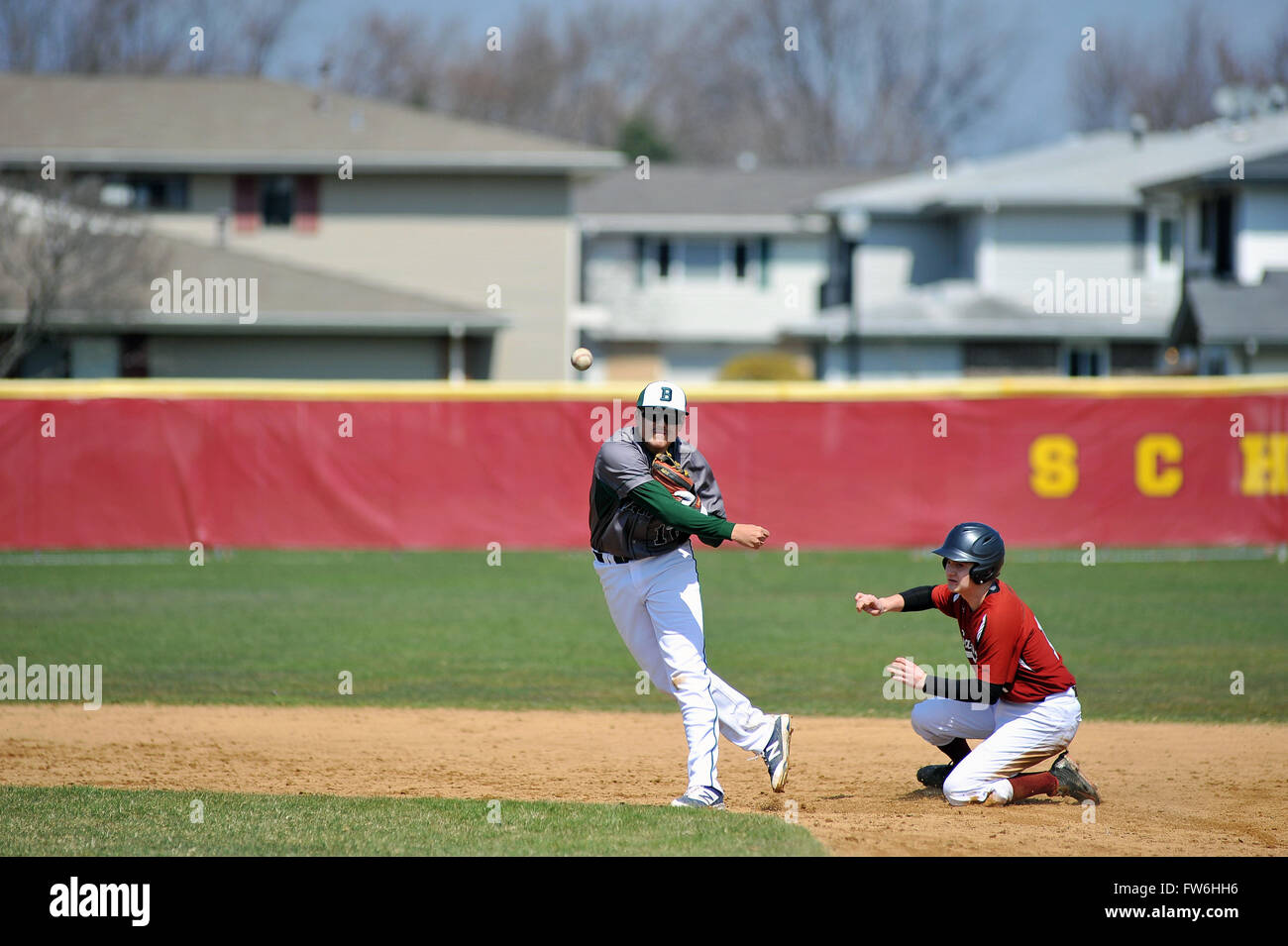 After avoiding a sliding runner, a high school second baseman comes ...